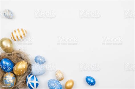 부활절 황금 파란색 은 웹 배너흰색 배경에 고립 된 둥지에 계란을 장식 최소한의 부활절 개념 텍스트에 대한 복사 공간이있는 행복한 부활절 카드 상단 보기 플랫레이 4월에