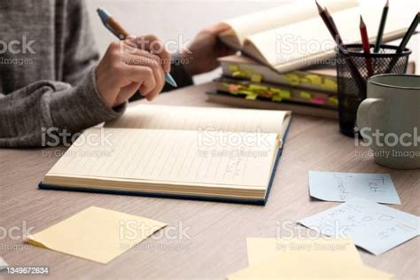 광고 텍스트를 쓰는 여성 카피라이터로 여자 책상 과 책의 스택의 클로즈업 노트북 고정 그것에 종이 작가에 대한 스톡 사진 및