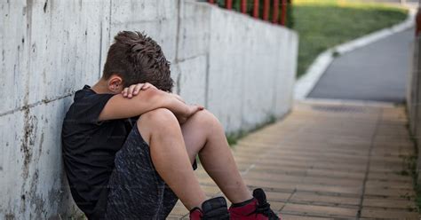 학교에 혼자 앉아 슬픈 어린 소년은 얼굴을 숨 깁니다 격리와 괴롭힘 개념 아이 슬프고 불행한 아이는 울고 화나고