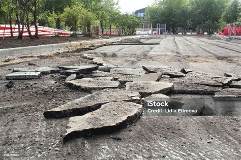 금이 가고 부서진 아스팔트 도로가 그 아래 땅을 드러냅니다 도시의 쇠퇴와 방치 큰 움푹 들어간 곳과 깨진 포장 도로가있는 황폐한 도시 거리 방치와 수리의 필요성 거리에 대한