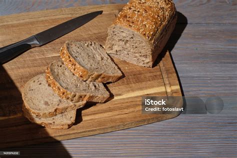 빵 커팅 보드에 칼로 갓 구운 빵 한 덩어리 어두운 테이블에 씨앗이있는 장인 빵 소박한 사워도우 빵 0명에 대한 스톡 사진 및 기타 이미지 Istock