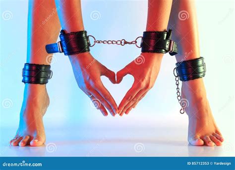 Female Legs Barefoot On Tiptoes In Leather Cuffs And Hands In Cuffs