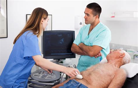 현대 초음파 기계로 환자를 검사하는 두 명의 자신감 있는 초음파 검사자가 함께 일합니다 감정에 대한 스톡 사진 및 기타 이미지