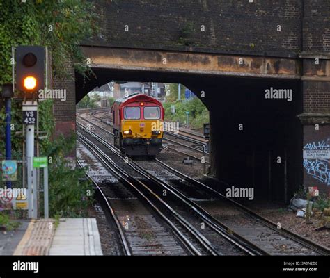 Db Cargo Rail Uk Class 66 Diesel Locomotive Running Light Engine With A Yellow Railway Signal