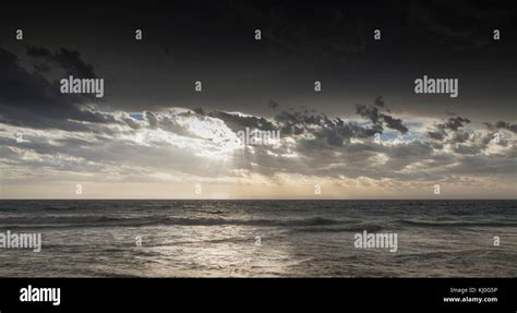 Sunlight Filtering Through Clouds At Sunset Stock Photo Alamy