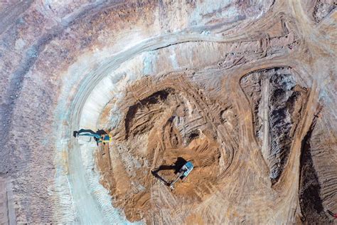 Premium Photo Open Pit Mine In Full Operation With Machinery Extracting Minerals