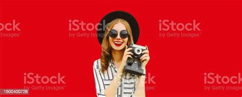 빨간 배경에 검은 둥근 모자를 쓰고 필름 카메라를 들고 행복한 미소를 짓고 있는 젊은 여성 사진작가의 여름 초상화 빨강에 대한 스톡 사진 및 기타 이미지 Istock