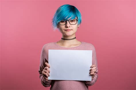 흰색 A4 종이 포스터를 들고 파란색 머리와 예쁜 소녀입니다 공간을 복사합니다 핑크 스튜디오 배경에 트렌디 한 여자를 미소 갈색 머리에 대한 스톡 사진 및 기타 이미지