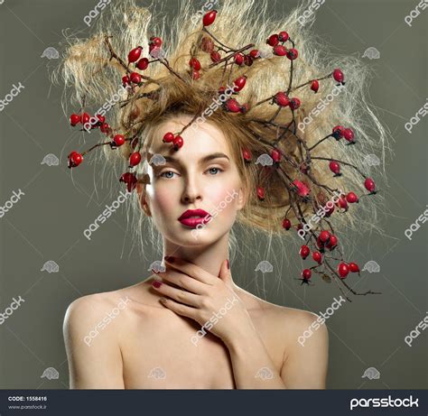 زنی زیبا با سر شاخه گل رز وحشی توت قرمز در موهای او 1558416
