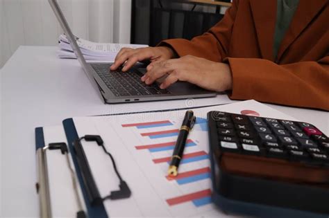 businessman hands searching for data on notebook with analyzing charts at his workplace stock