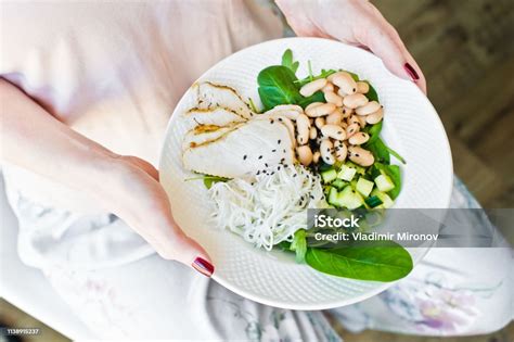 소녀는 건강 한 균형 잡힌 음식의 그릇 유리 국수 콩 닭 가슴살 시금치 Arugula 및 오이를 보유 하 고 있습니다 흰색 배경 평면도 균형에 대한 스톡 사진 및 기타