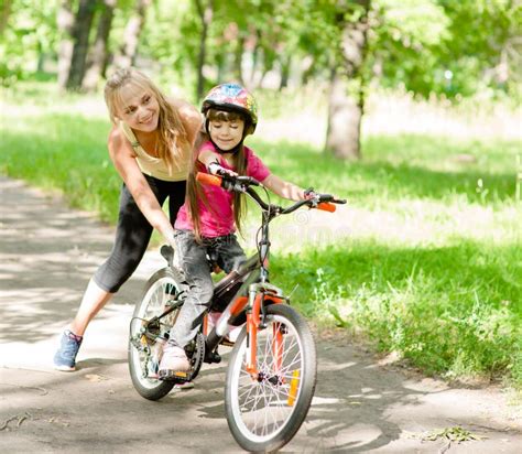 La Madre Felice Insegna A Sua Figlia A Guidare Una Bici Immagine Stock Immagine Di Sano