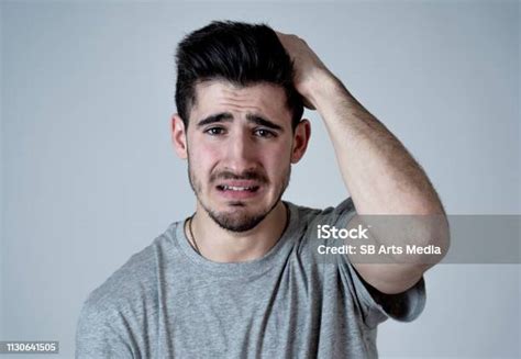 우울한 우울 하 고 슬픈 중립 배경에 고립 된 보고 우울증에서 고통을 울고 잘생긴 젊은 남자의 초상화를 닫습니다 사람의 얼굴 표정과 감정의 개념 감정에 대한 스톡 사진 및