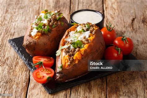 렌틸콩 마늘 파슬리로 속을 채운 소박한 스타일의 구운 고구마는 슬레이트 보드에 사워 크림 클로즈업과 함께 제공됩니다 수평 0명에 대한 스톡 사진 및 기타 이미지 Istock