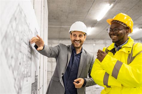 건설 노동자와 구조 엔지니어가 새로운 건물 프로젝트에 대해 논의하고 있다 Teamwork Makes The Dream Work에 대한 스톡 사진 및 기타 이미지