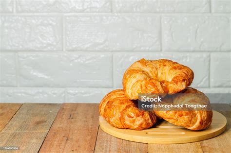 수제 크루아상 3개가 나무 트레이에 놓여 있으며 흰색 벽돌을 배경으로 나무 테이블에 놓여 있습니다 갈색에 대한 스톡 사진 및 기타 이미지 Istock