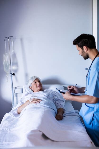 Doctor Hombre Discutiendo Informe Médico Con Paciente Senior Femenino