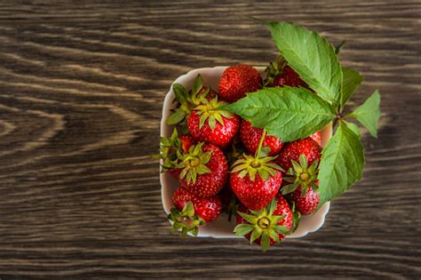 작은 흰색 도자기 그릇 즙이 육즙 신선한 익은 빨간 딸기는 오래 된 나무 질감된 테이블 위에 가득합니다 신선한 딸기입니다 나무 테이블에 딸기 0명에 대한 스톡 사진 및 기타