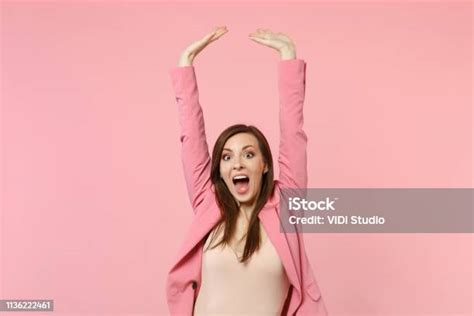 스튜디오에서 파스텔 분홍색 벽 배경에 고립 된 입 넓은 오픈 상승 손을 유지 쾌활 한 재미 아름 다운 젊은 여자의 초상화 사람들은 진심으로 감정 라이프 스타일 개념입니다