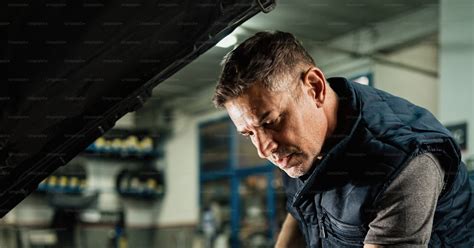 자동차 정비소에서 일하는 동안 자동차 엔진의 오일을 검사하는 자동차 정비사 사진 Unsplash의 자동차 이미지