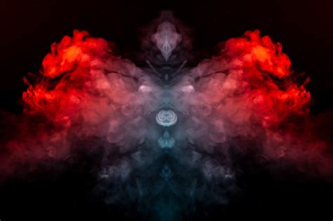 파란색의 배경 귀신의 머리의 모양 또는 검은색 신비로운 외모의 남자에서 빨간색과 녹색 물결 모양의 연기 접지 절연 밝은 추상 패턴 Vape에서 증기의 검은색에 대한 스톡