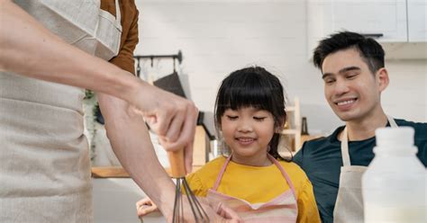 아시아의 매력적인 Lgbtq 게이 가족은 효모 반죽을 만드는 소녀 아이를 가르칩니다 잘 생긴 남자 부부는 부엌에서 작은