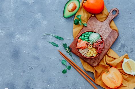 하와이 연어는 쌀 아보카도 오이 당근 추카 참깨를 파란색 배경에 넣은 그릇을 찌르고 있습니다 맨 위 보기 0명에 대한 스톡 사진 및 기타 이미지 Istock