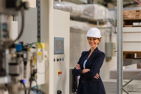 Female Manager Standing In Modern Industrial Factory Manufacturing Facility With Robotics And