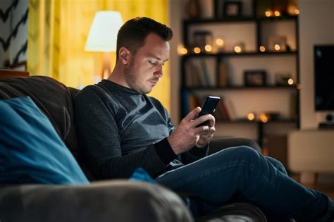 Man Using Phone Man Sitting Home In His Armchair And Using Phone