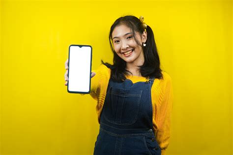 예쁘고 귀여운 젊은 여성 쾌활 자신감 스마트 폰을 들고 손 빈 또는 흰색 화면 스마트 폰 응용 프로그램을 홍보 제품 홍보 광고