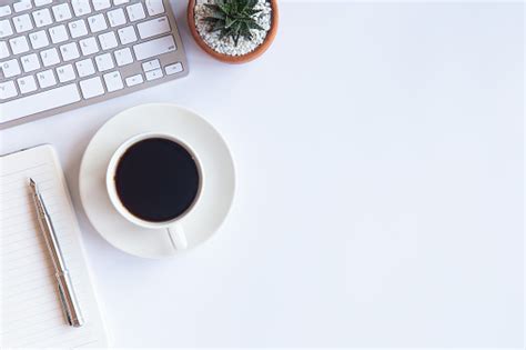 노트북 스마트폰 및 기타 업무 용품이 있는 화이트 데스크 오피스와 커피 한 잔이 있습니다 텍스트를 입력하기 위한 복사 공간이 있는 상단 보기입니다 평면 평지에 책상 테이블