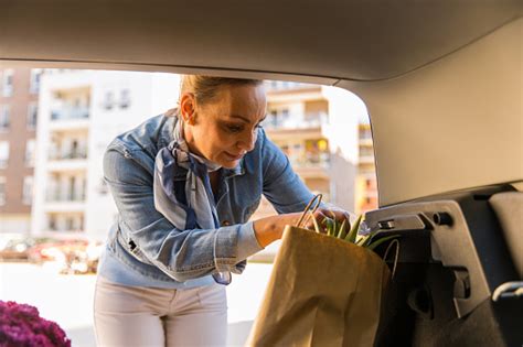 커브사이드 픽업을 하는 동안 자동차 트렁크에 식료품 가방을 싣고 50 54세에 대한 스톡 사진 및 기타 이미지 50 54세 고객 국화 Istock