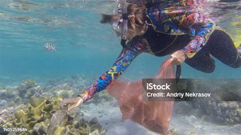 다이빙 장비를 착용 한 여성은 산호초 바닥에서 수중 플라스틱 파편을 수영하고 수집합니다 플라스틱 오염으로부터 바다를 청소하는 스노클러 바다의 플라스틱 오염 홍해 이집트 45