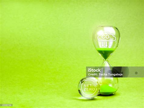 Net Zero 카운트다운 이산화탄소 감축 환경 지속 가능성 개념 모래 시계의 Co2 배출량 아이콘과 유리 지구 지구의 Net Zero 기호 복사 공간이 있는 녹색 배경 0