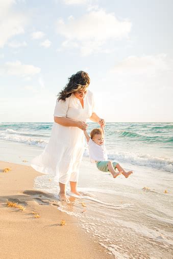 31세의 쿠바계 미국인 어머니가 2023년 봄 플로리다주 팜 비치에서 황금빛 일출을 보며 해변 해안가에서 1살 된 아들과 함께 시간을 즐기고 있습니다 12 17 개월에 대한