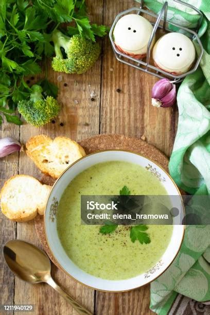 채식 요리 맛있는 브로콜리 크림 수프와 마늘 크루통을 소박한 식탁에 올려놓습니다 상단보기 평면 누워 배경입니다 공간을 복사합니다