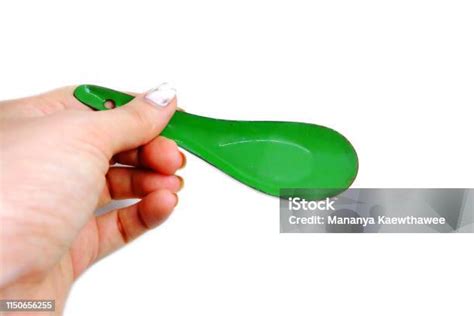 숟가락을 들고 잘 손질 된 화강암 손톱과 여자 손 흰색 바탕에 녹색 아연 숟가락을 닫습니다 가장자리에 대한 스톡 사진 및 기타