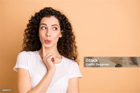 턱에 손가락을 들고 놀라운 여자의 클로즈업 사진 교활한 빈 공간을 찾고 까다로운 액션 착용 화이트 캐주얼 의상 고립 된 베이지 색 색상 배경 T 셔츠에 대한 스톡 사진 및