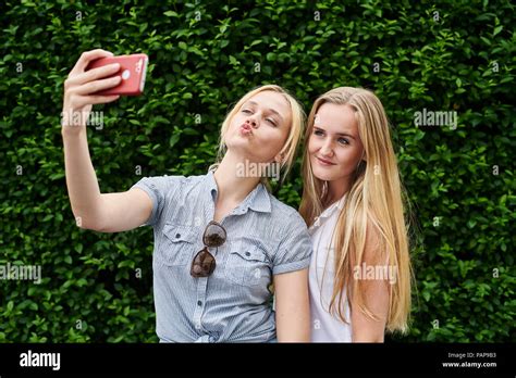 Deux jeunes femmes posant pour une couverture à un selfies Photo Stock Alamy