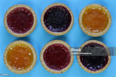 딸기 라즈베리 살구 잼이 가득한 작은 수제 잼 타르트 파이를 이미지한 청록색 배경에 애프터눈 티 어린이 생일 파티 음식 뷔페