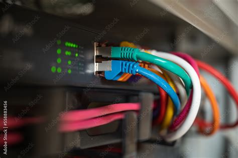 Patch Panel And Switch With Colorful LAN Cables In A Network Cabinet Of A Data Center Stock