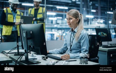 Car Factory Team Of Engineers Discuss Project Female Technician Working On Computer