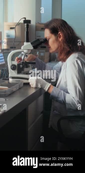 Female Chemist Or Microbiologist Conducts Fossil Analysis Under
