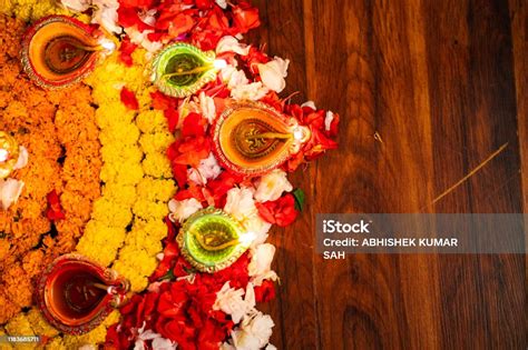 디왈리를 계기로 꽃을 배경으로 오일 램프 조명이나 디야를 들고 전통 사리 드레스를 입은 아름다운 젊은 인도 여성 Onam에 대한 스톡 사진 및 기타 이미지 Istock