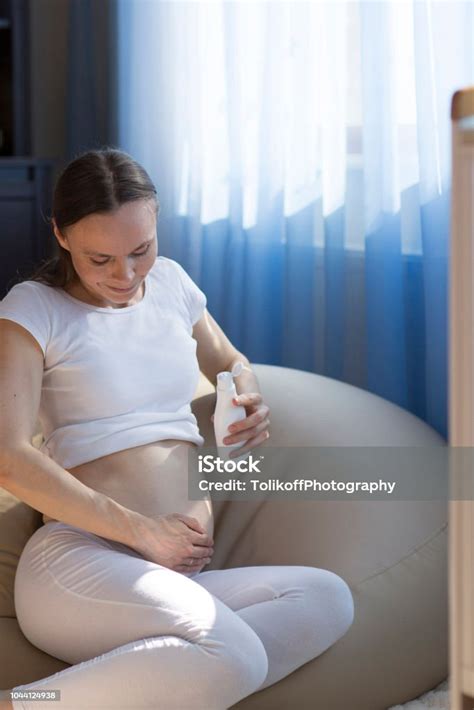 Junge Schwangere Frau Setzt Die Sahne Auf Den Bauch Stockfoto Und Mehr