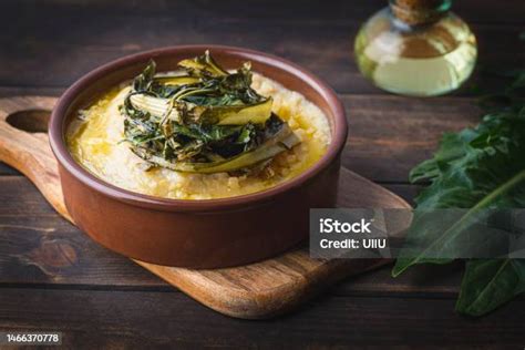 Pugliese 조리법 Fave E Cicoria 아스파라거스 치커리 이탈리아 민들레 치커리 또는 카탈로니아 치커리를 나무 소박한 테이블에 곁들인 파바 콩 또는 넓은 콩 죽