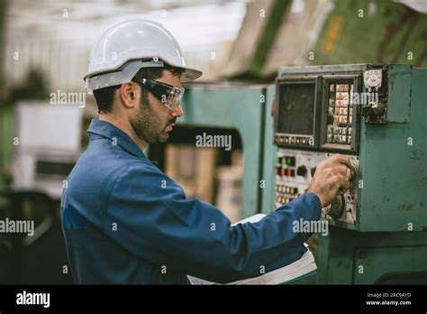 Hispanic Latin Indian Male Worker Working Control Operate Lathe Cnc Machine In Heavy Metal Steel