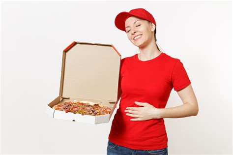 흰색 배경에 고립 된 빨간 유니폼에 배달 여자 꽤 여성 모자 티셔츠 청바지 택배 또는 골 판지 Flatbox에서 이탈리아 피자를 들고 딜러로 일하고 광고에 대 한 공간을
