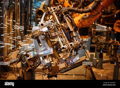 Modern Robot Welder Processes Metal Part In Factory Workshop Stock