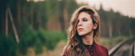 곱슬 자연 머리를 가진 아름 다운 소녀 철도에 숲에서 자연을 즐길 수 있습니다 철도에 부르고뉴 드레스를 걸어 꿈꾸는 레이디 새벽에 레일에 영감을 여자의 여성 초상화입니다